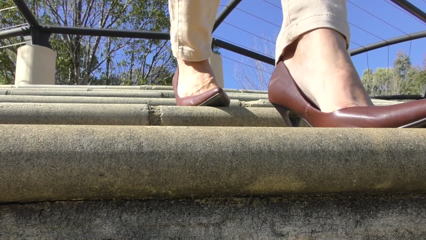 Attractive Woman In High Heel Shoes Walking Up Steps Or Stairway Outdoors Wearing Brown Pumps
