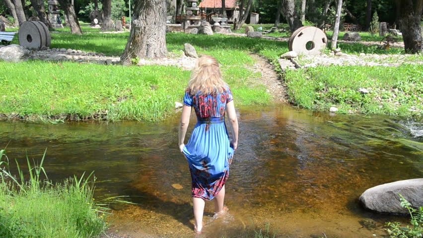 Young Girl Holds A Dress Skirt And Wade Barefoot Pebble Creek Sunny